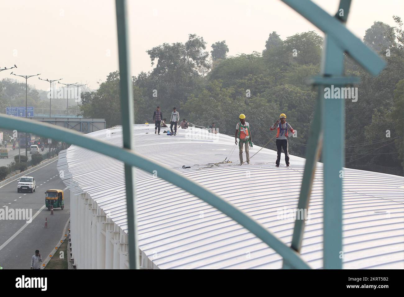 Labourers cut metal girders with safety measures at an under ...
