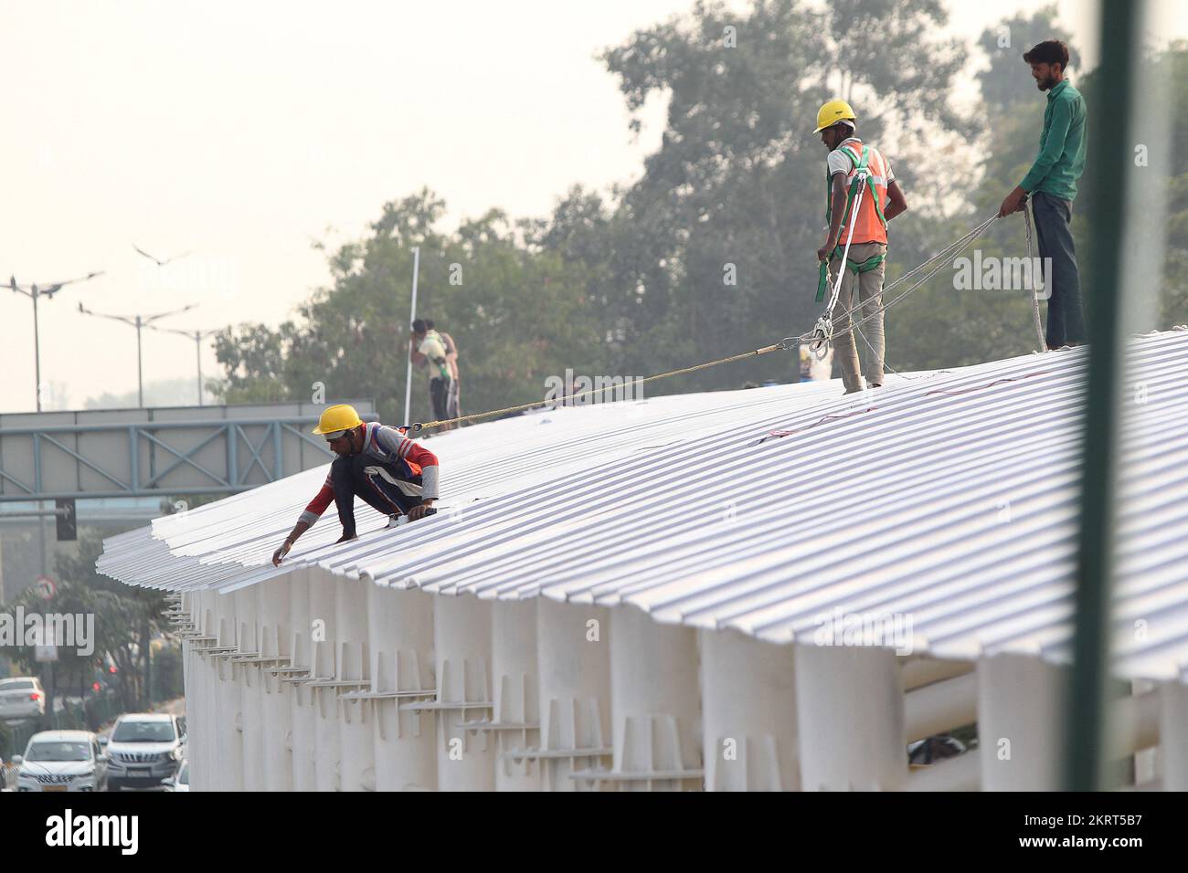 Labourers cut metal girders with safety measures at an under ...