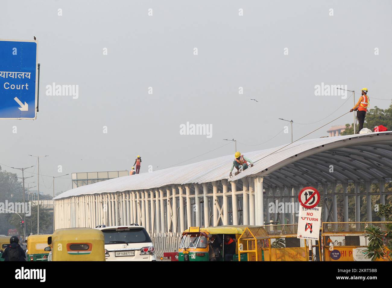Labourers cut metal girders with safety measures at an under ...