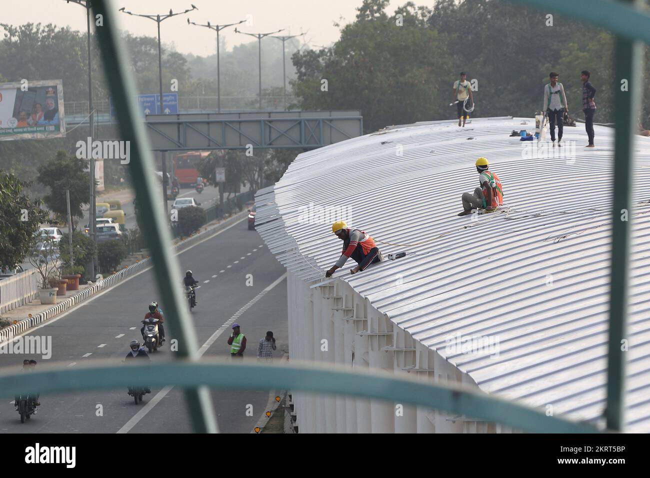 Labourers cut metal girders with safety measures at an under ...
