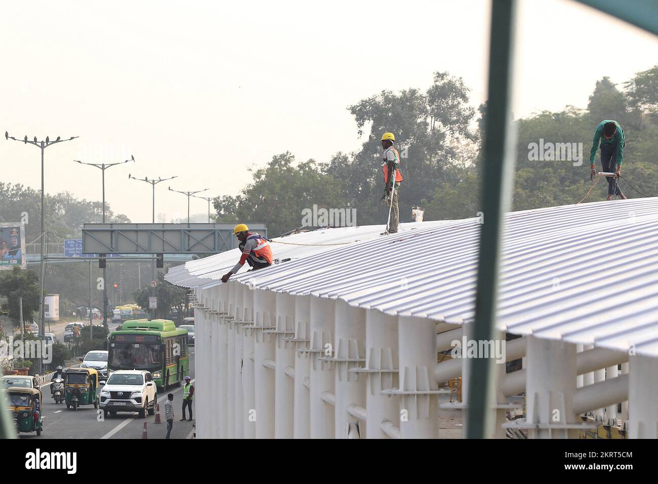 Labourers cut metal girders with safety measures at an under ...