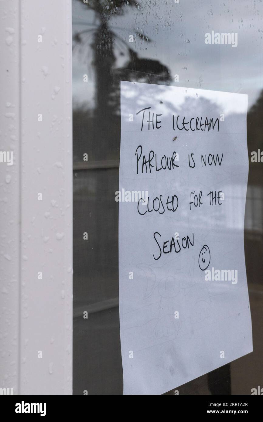 A handwritten closed sign in an Ice cream parlour window in the closed ...
