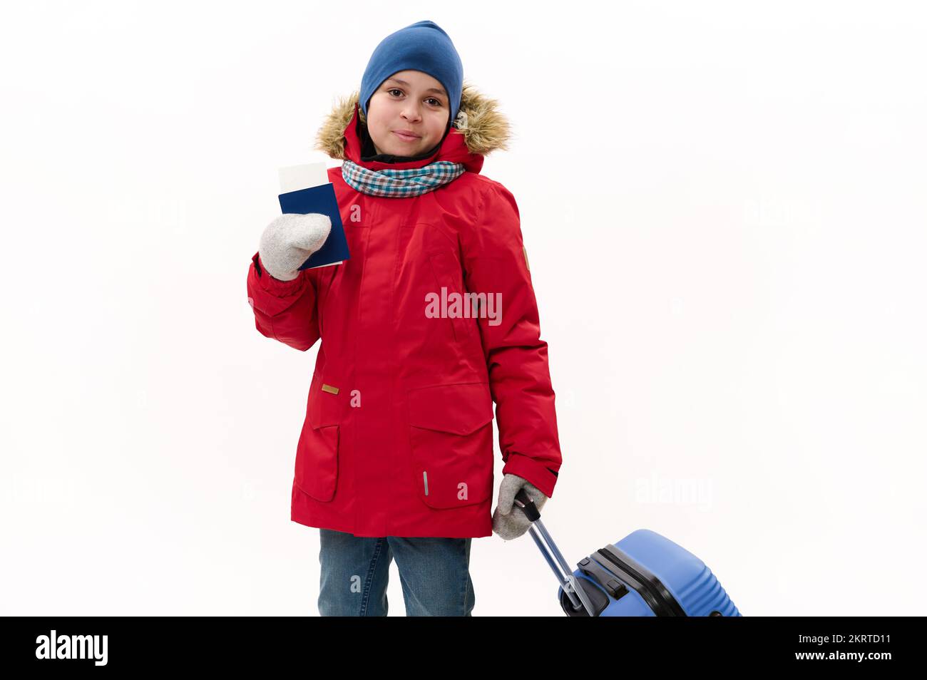 Happy traveler boy in red parka, jeans, wool mittens, goes for winter ...