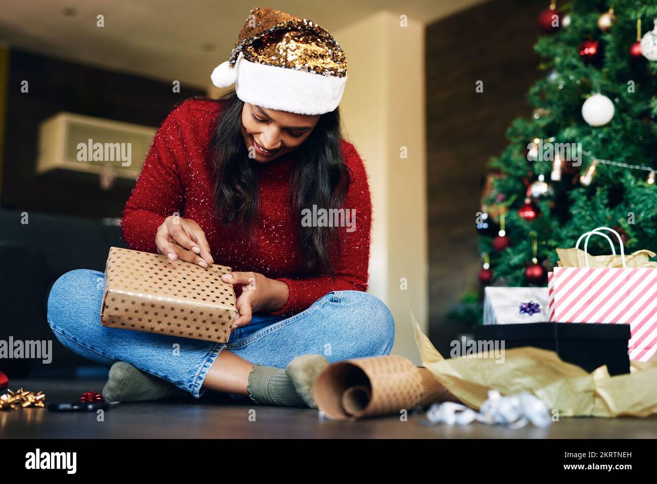 Woman, Christmas and gift wrapping by the tree for festive season ...