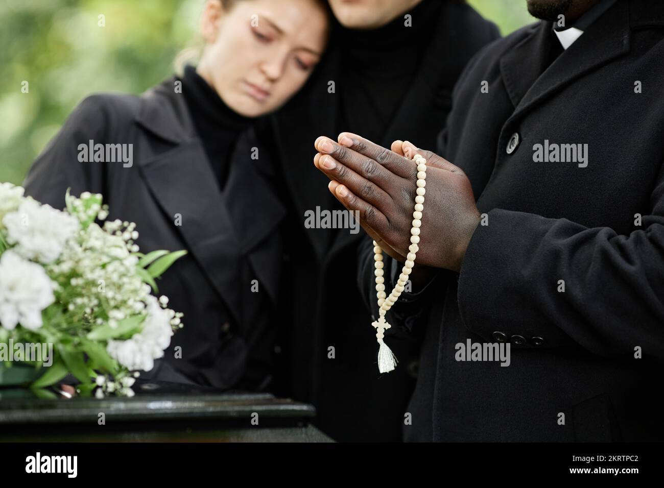 Close up of people wearing black at outdoor funeral ceremony with focus ...