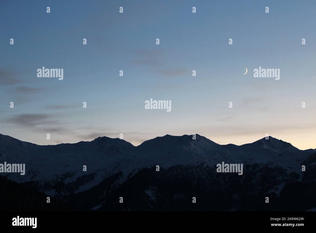 European alps covered in snow cast in shadow at twilight with gorgeous ...