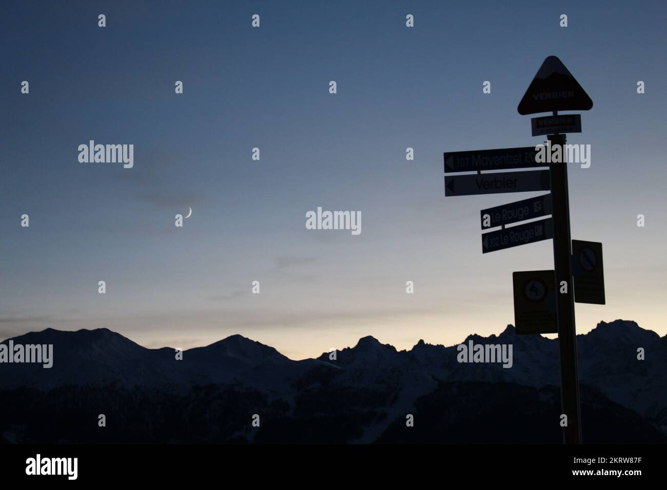 Silhouette of signs atop a mountain in the Swiss alps at twilight with ...