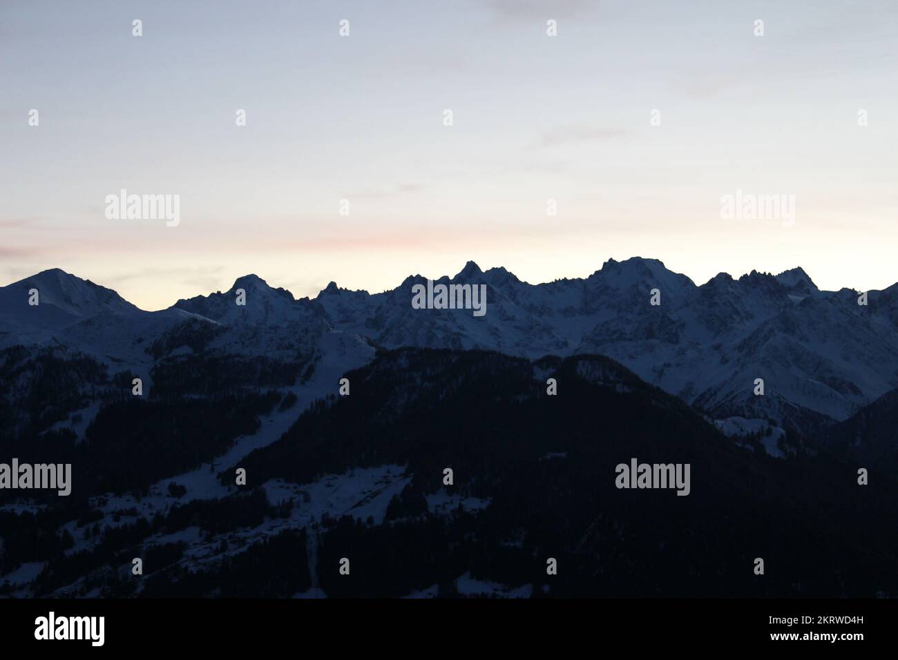 Sun setting behind swiss alps covered with small dusting of snow ...