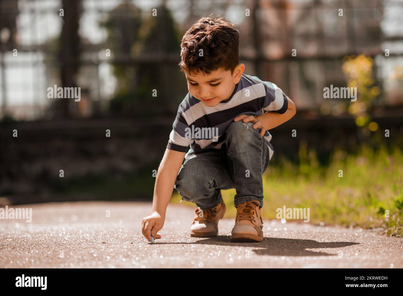Boy drawing something on the ground Stock Photo - Alamy