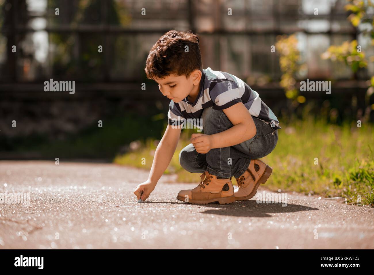 Boy drawing something on the ground Stock Photo - Alamy