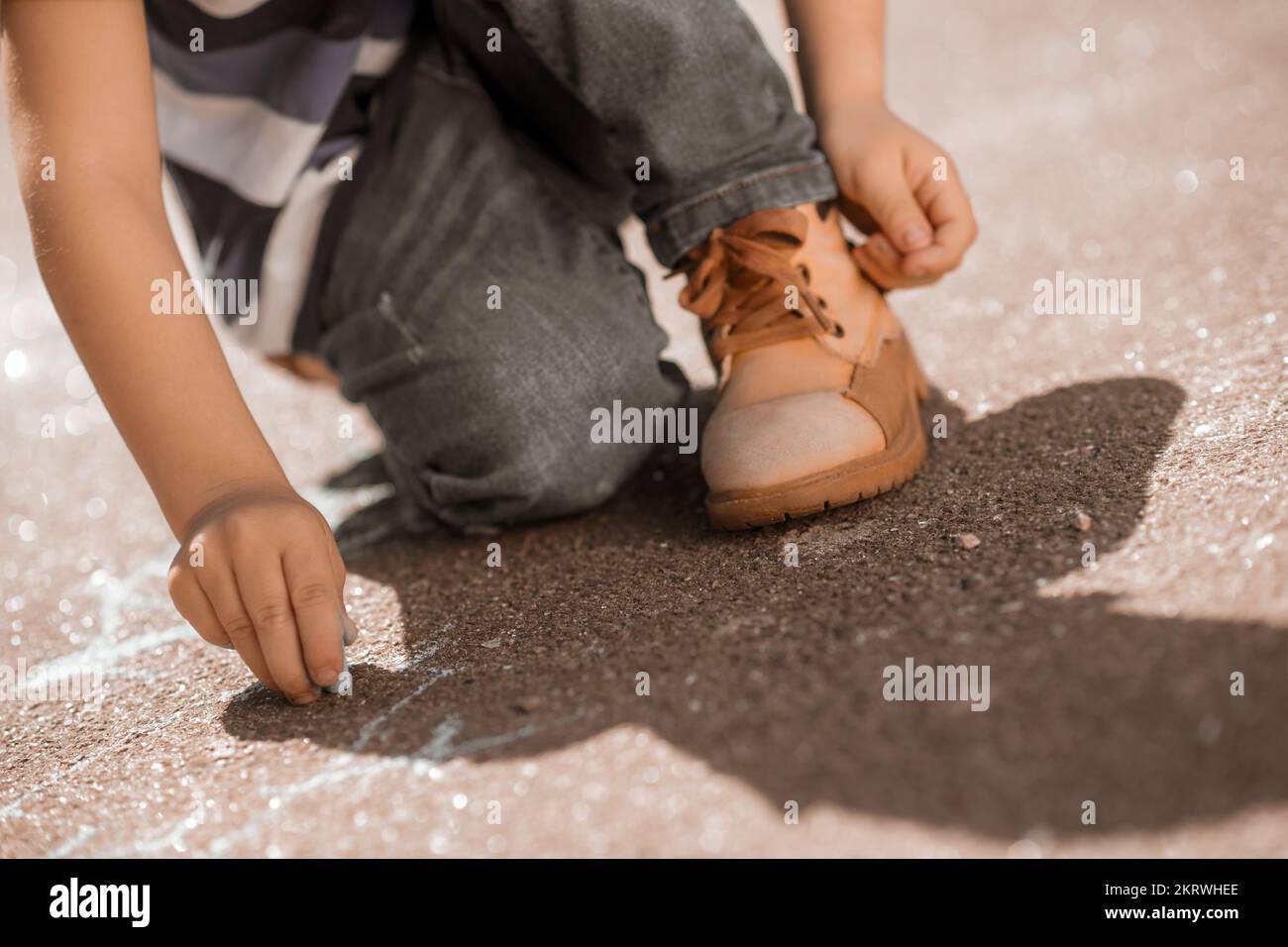 Boy drawing something on the ground Stock Photo - Alamy