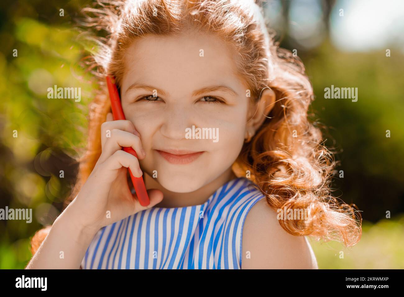 Cute girl in a blue dress talking on the phone Stock Photo - Alamy