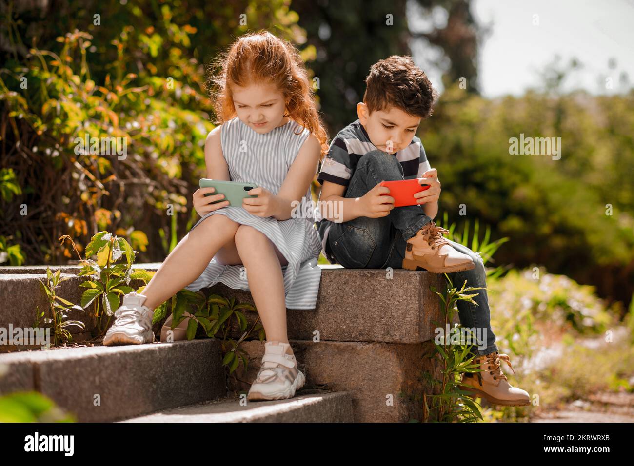 Two kids sitting together and watching something online Stock Photo - Alamy