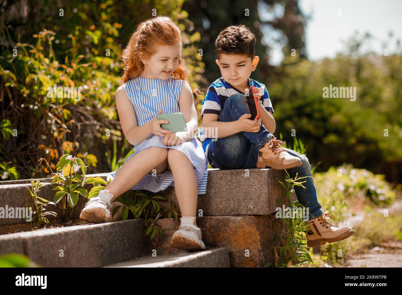 Two kids sitting together and watching something online Stock Photo - Alamy