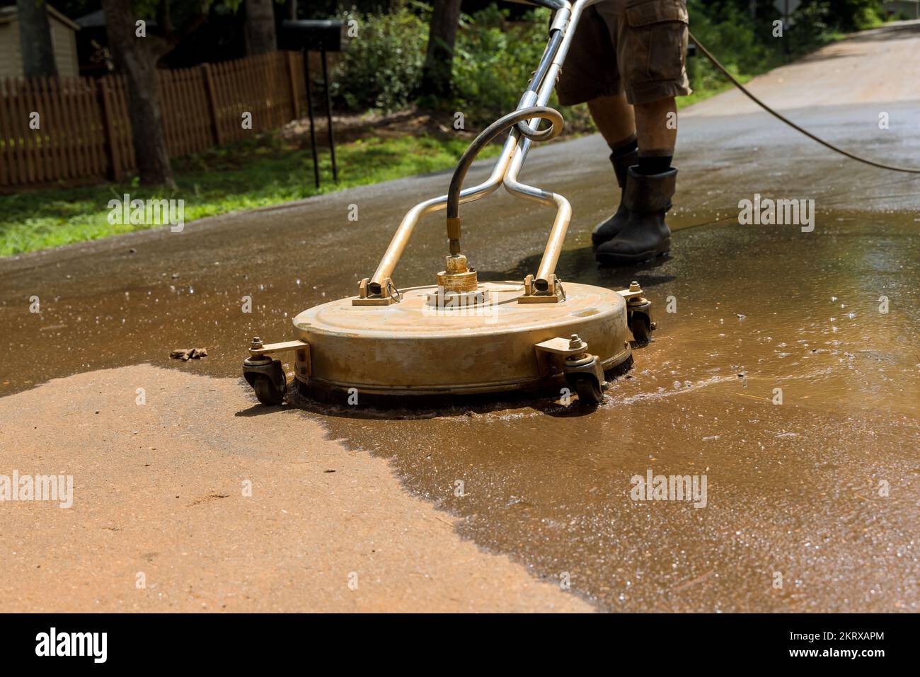 Using cleaning machine worker cleans street with help of high pressure ...