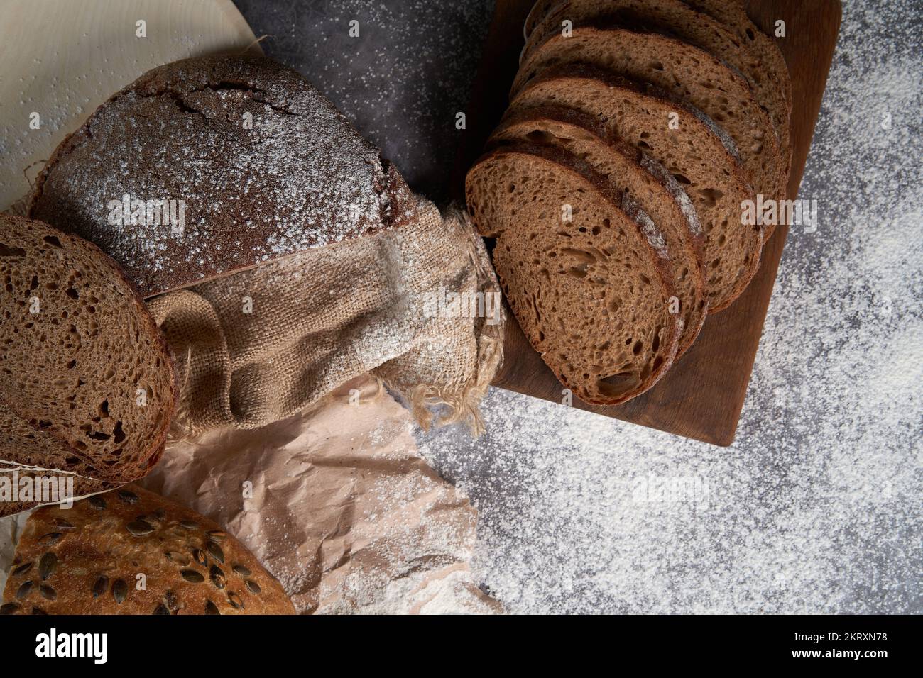 Top view of various types of bread, sliced and whole, flour, crumpled ...
