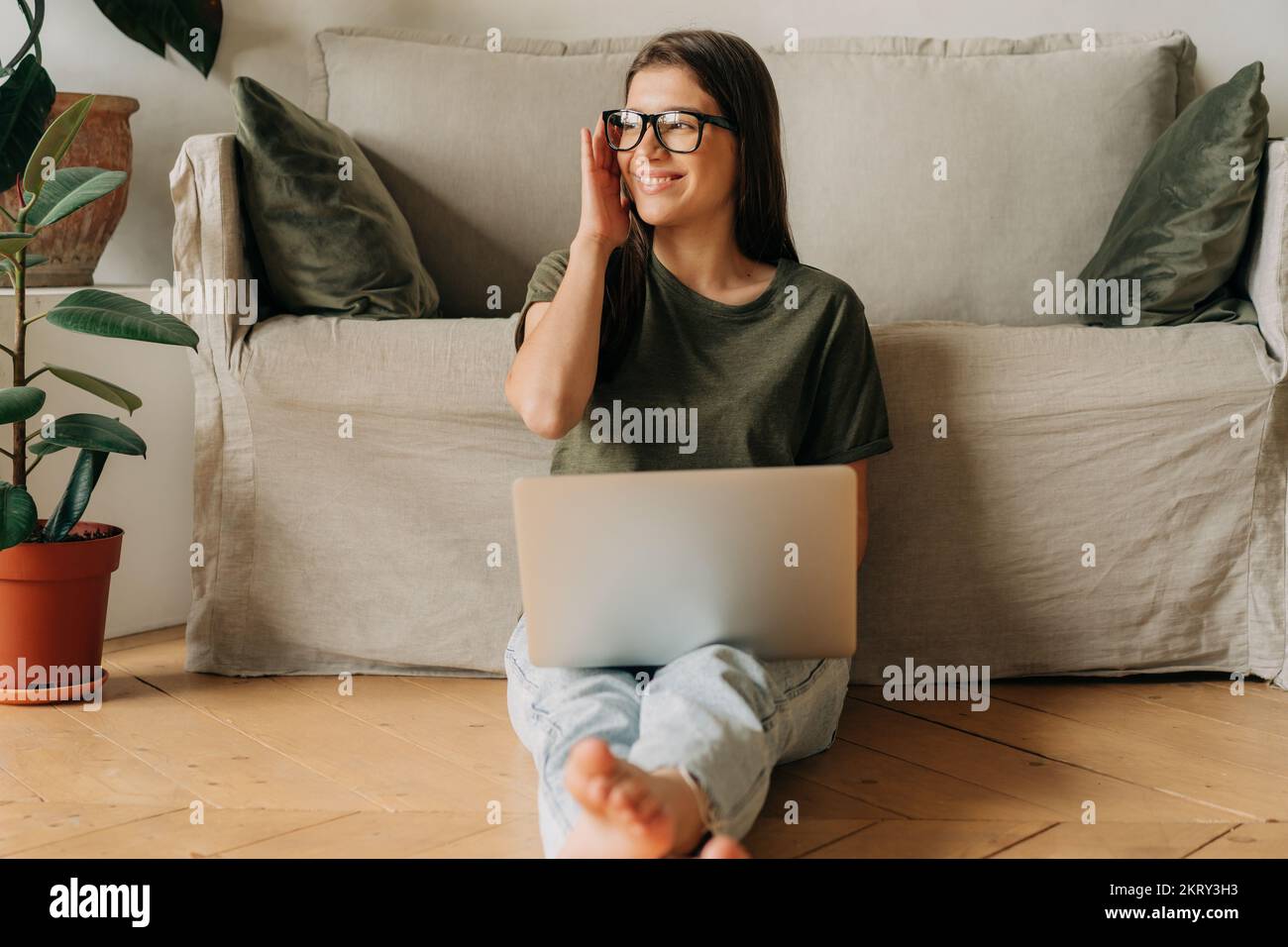 Happy smiling young woman working from home on laptop while sitting on ...