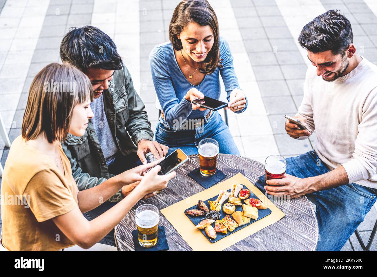 Generation z group of friends at pub, people having fun and using smart ...