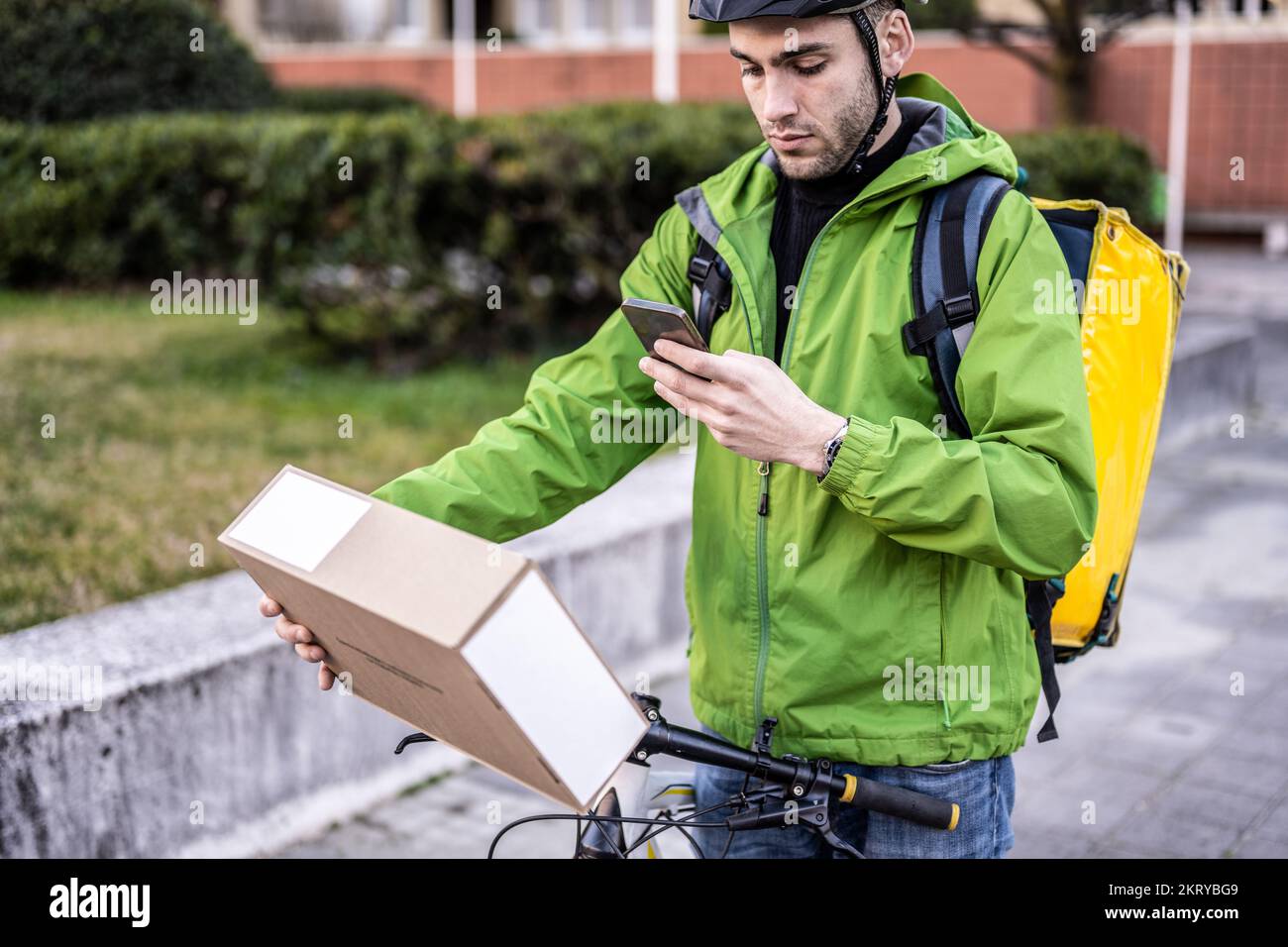 handsome young man using bicylce to deliver boxes, documents and food ...