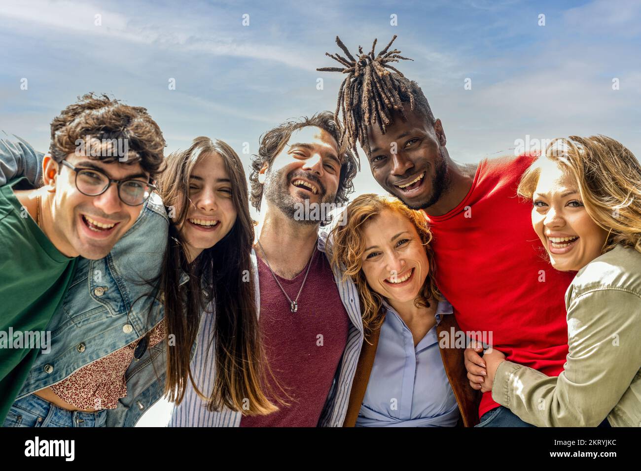 portrait of six people smiling in front of the camera on sunny day ...