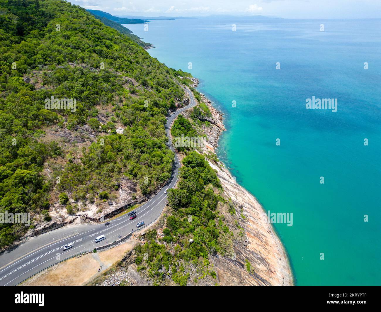 Aerial view of tropical winding road following blue ocean and ...