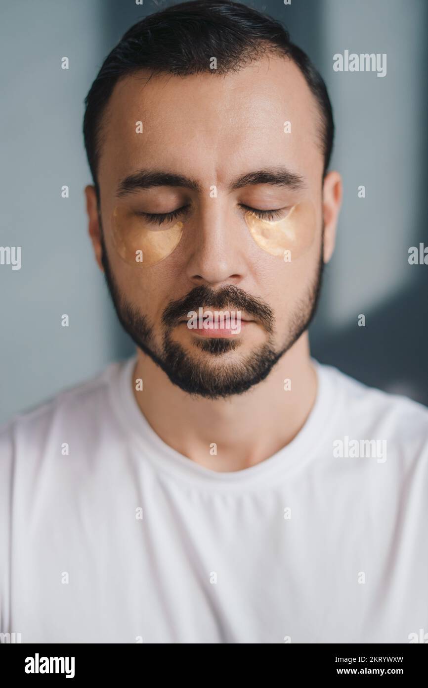Close-up front view portrait of young bearded man with applied eye ...