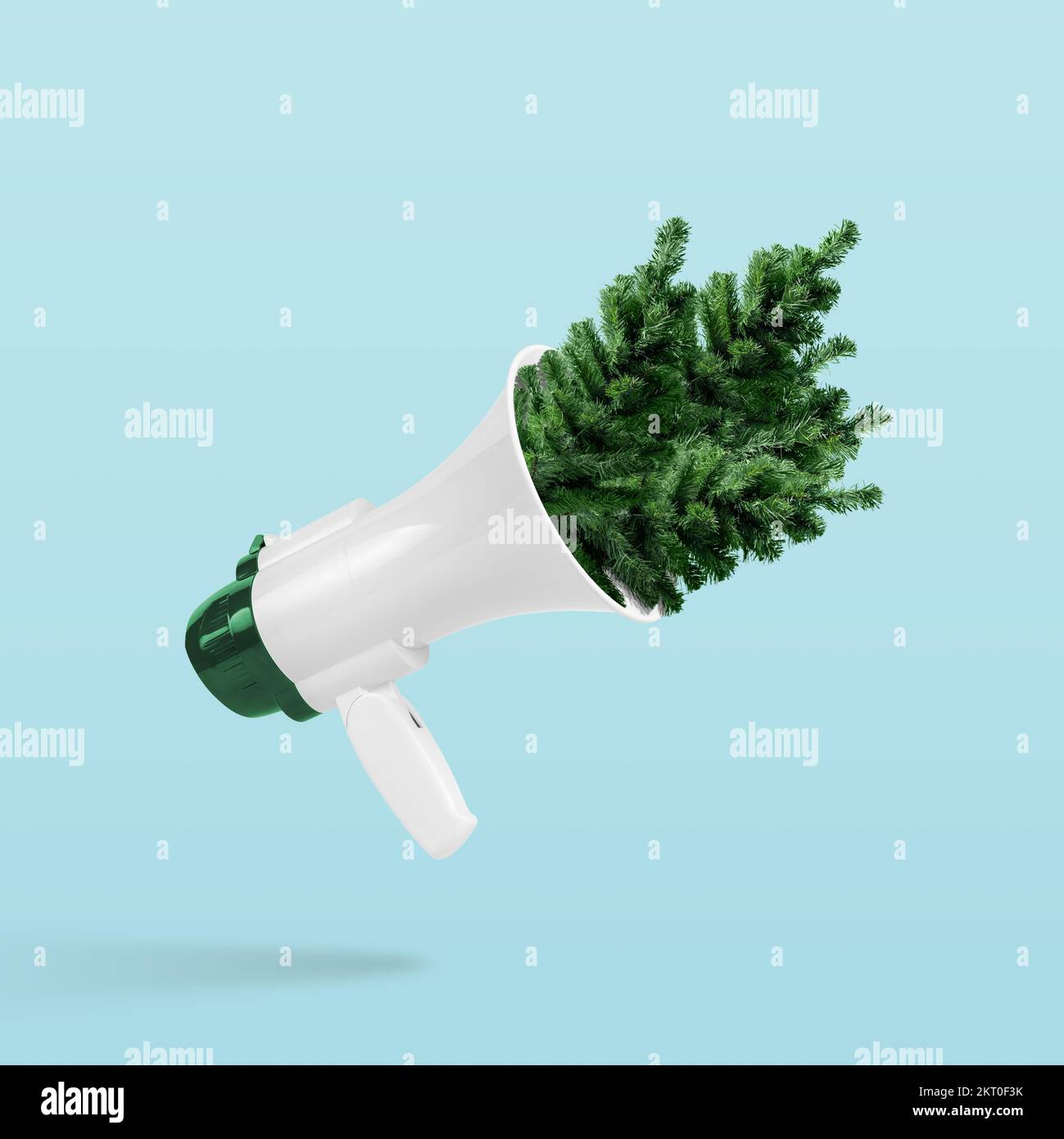 Christmas trees stick out of a megaphone on bright blue background ...