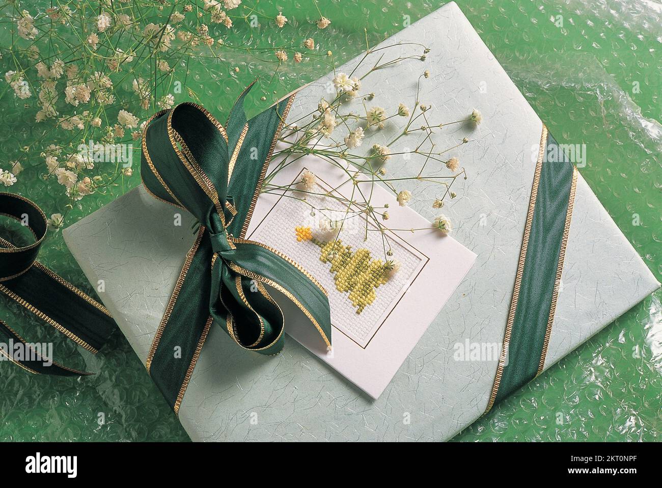 A plain wrapped parcel decorated with a double green bow Stock Photo ...