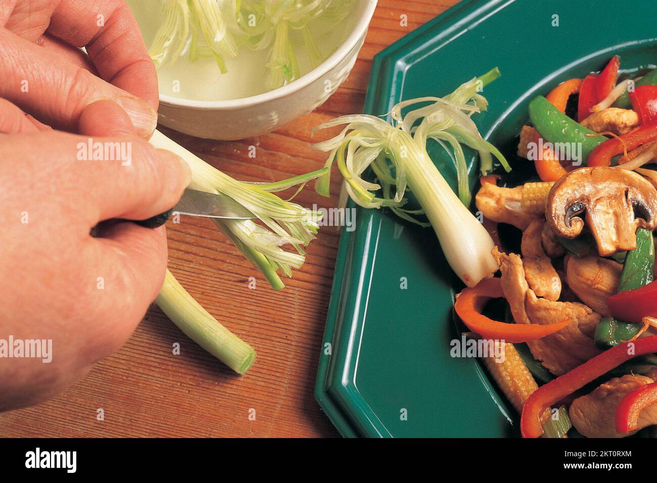 Slicing the ends of the spring onions Stock Photo - Alamy