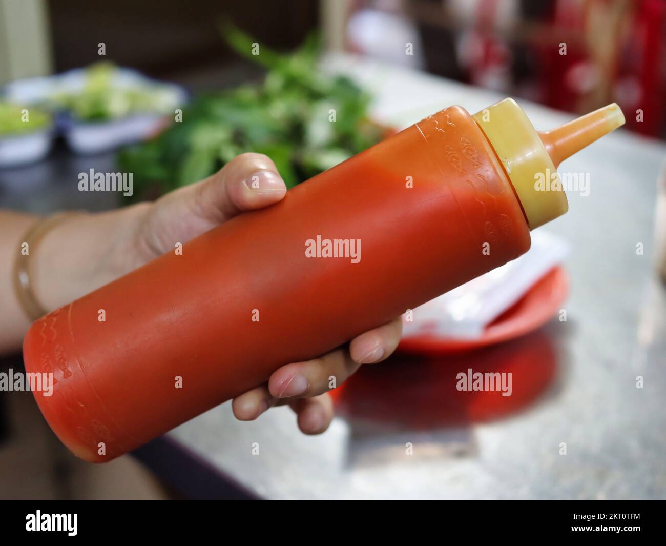 hand holding chili sauce Stock Photo - Alamy