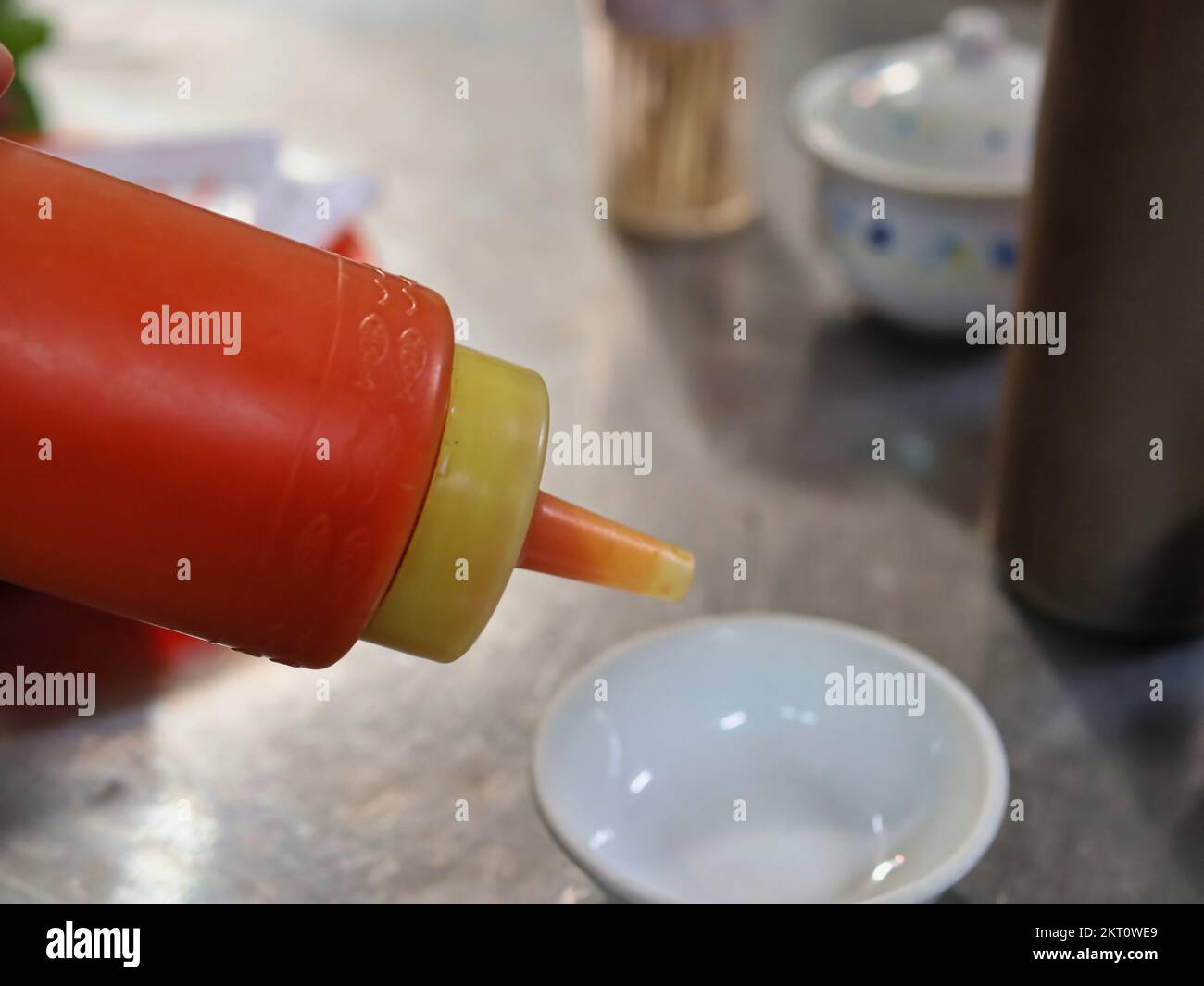 hand holding chili sauce Stock Photo - Alamy