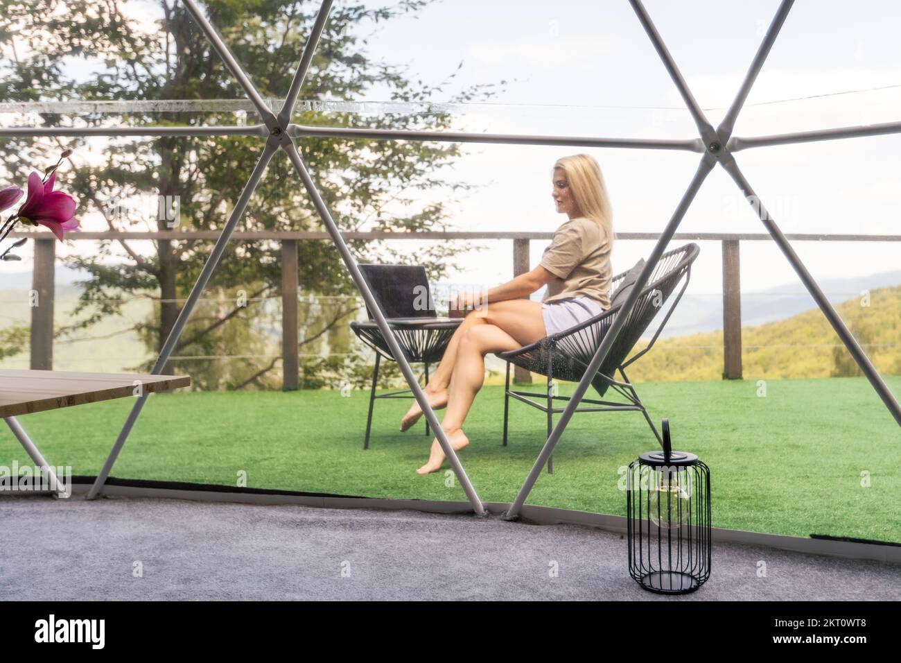 Woman working on laptop geo dome tents. Green, blue background. Cozy, camping, glamping, holiday ...