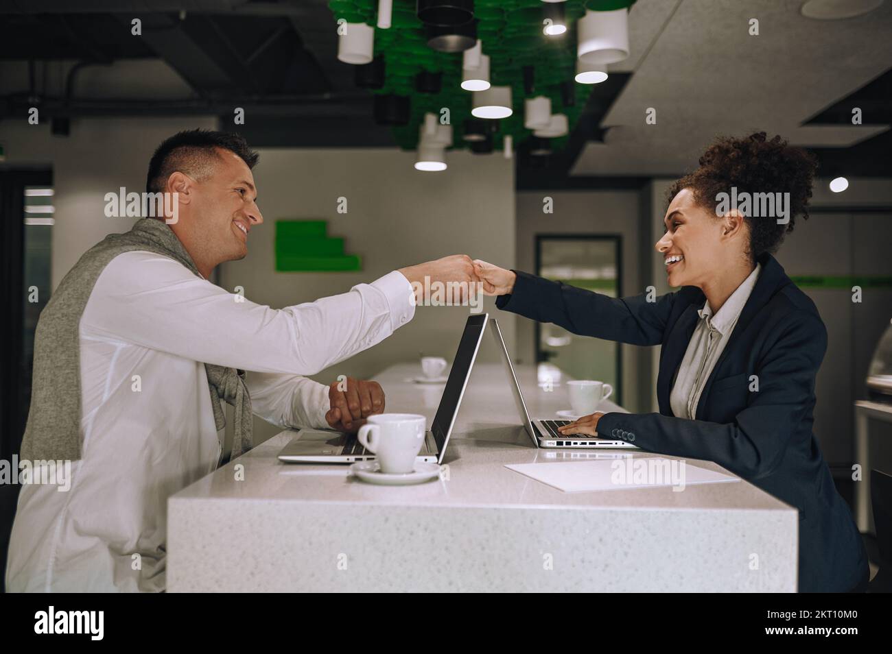Man and woman shaking hands sitting sideways to camera Stock Photo - Alamy