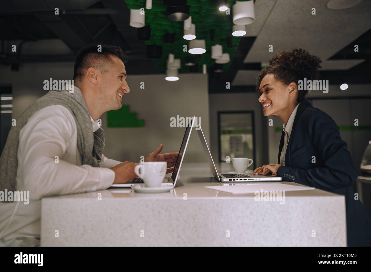 Man and woman sitting opposite looking at each other Stock Photo - Alamy