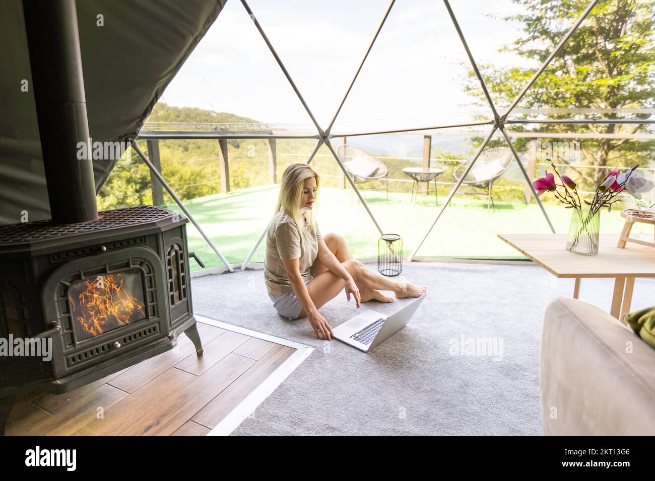 Woman working on laptop geo dome tents. Green, blue background. Cozy, camping, glamping, holiday ...