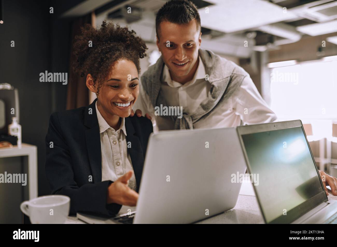 Woman showing laptop screen to male colleague Stock Photo - Alamy