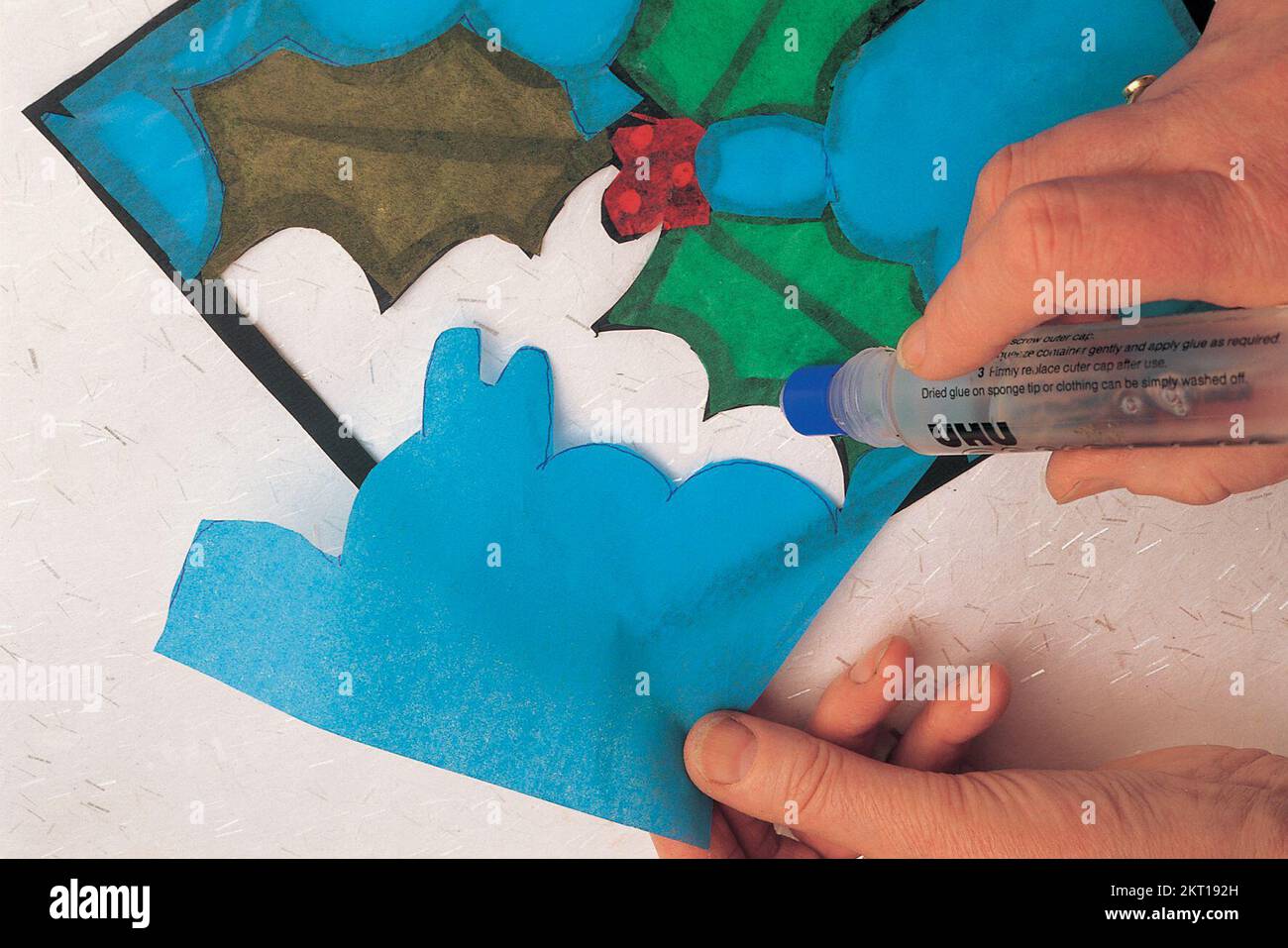 Gluing paper shape into position Stock Photo - Alamy