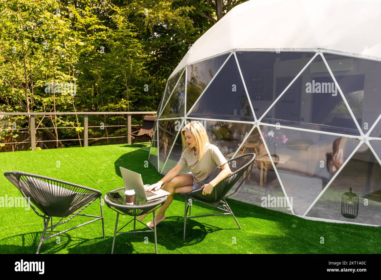 Positive woman chatting on laptop and and looking at screen near dome ...