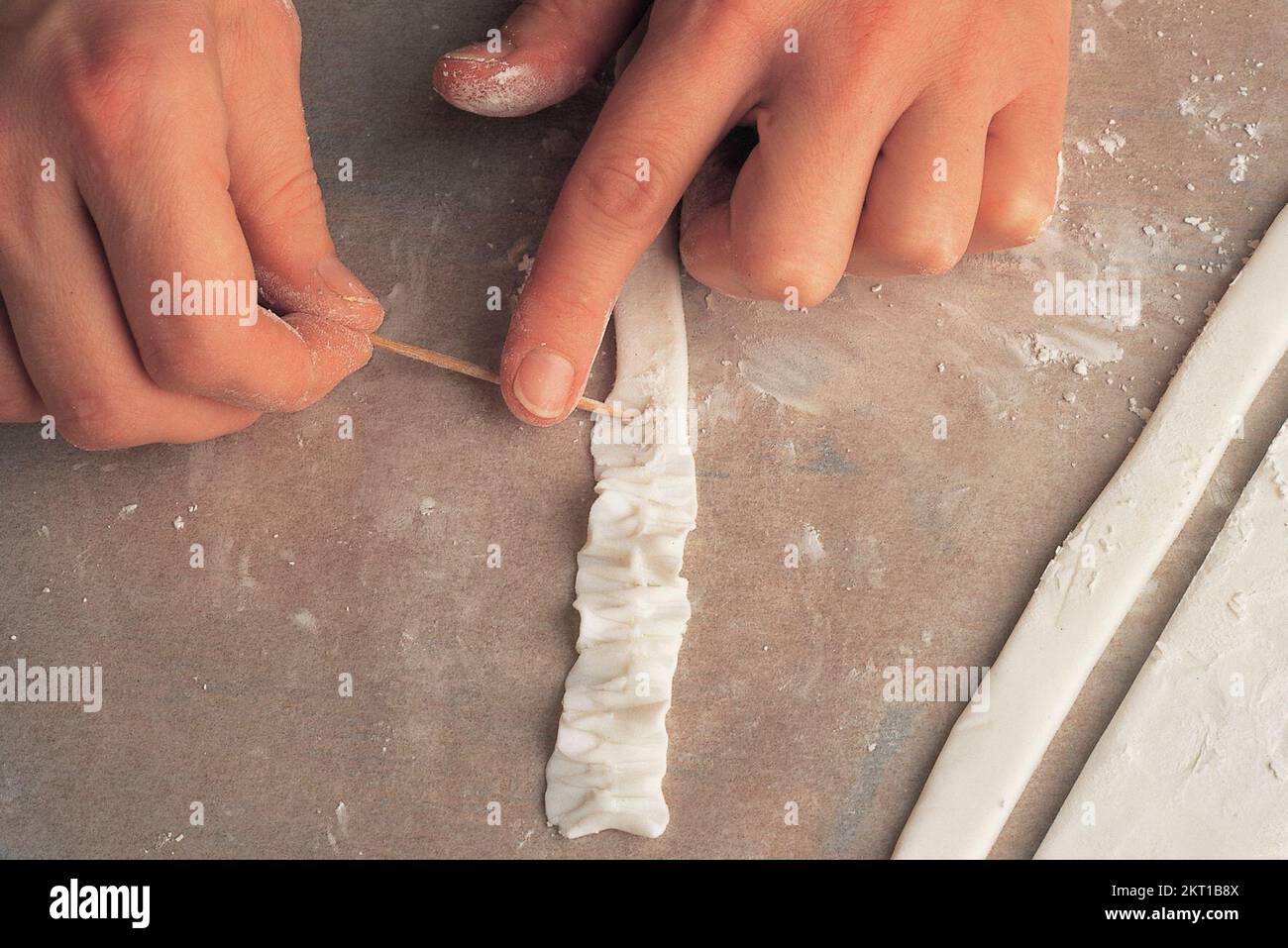 Denting strip of icing with cocktail stick Stock Photo - Alamy