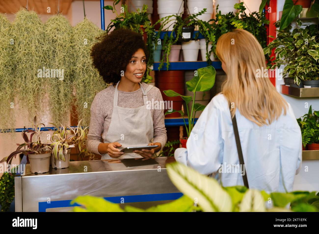 African american florist girl standing at cash register while working ...