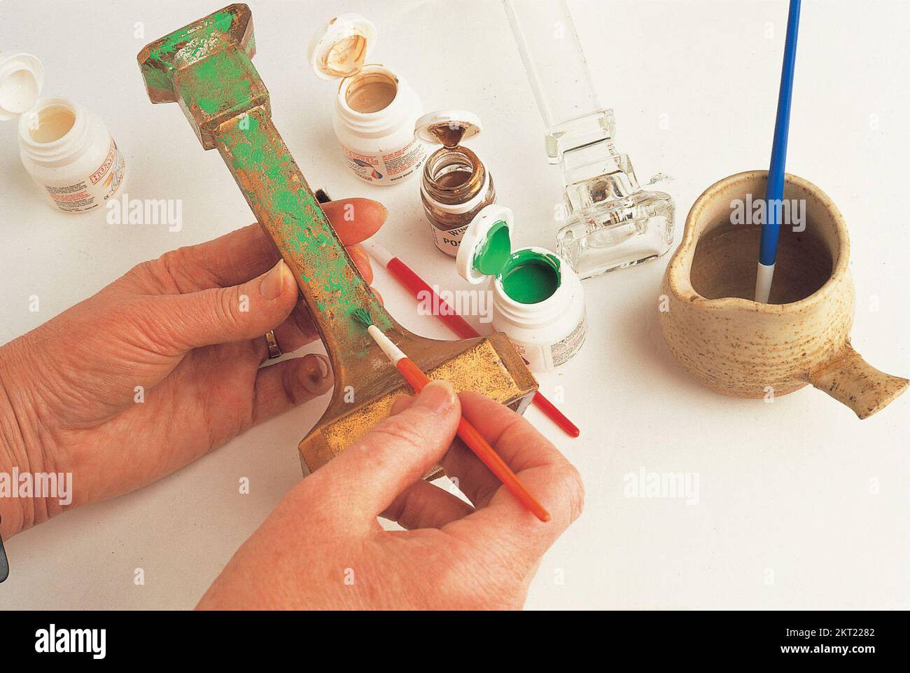 Daubing the candlestick in green paint Stock Photo - Alamy