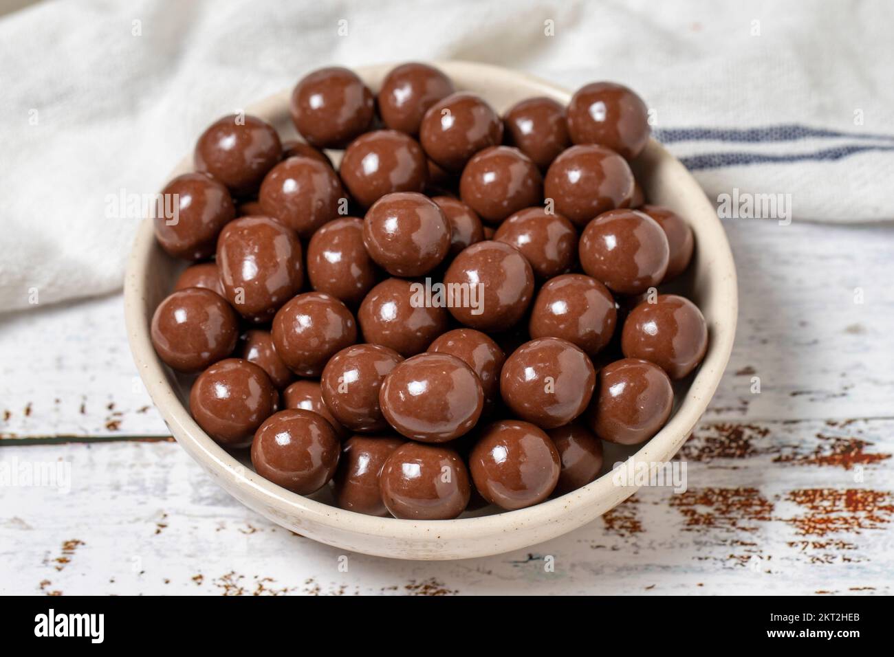 Chocolate coated hazelnut dragee. Hazelnut dragee chocolates on a white ...