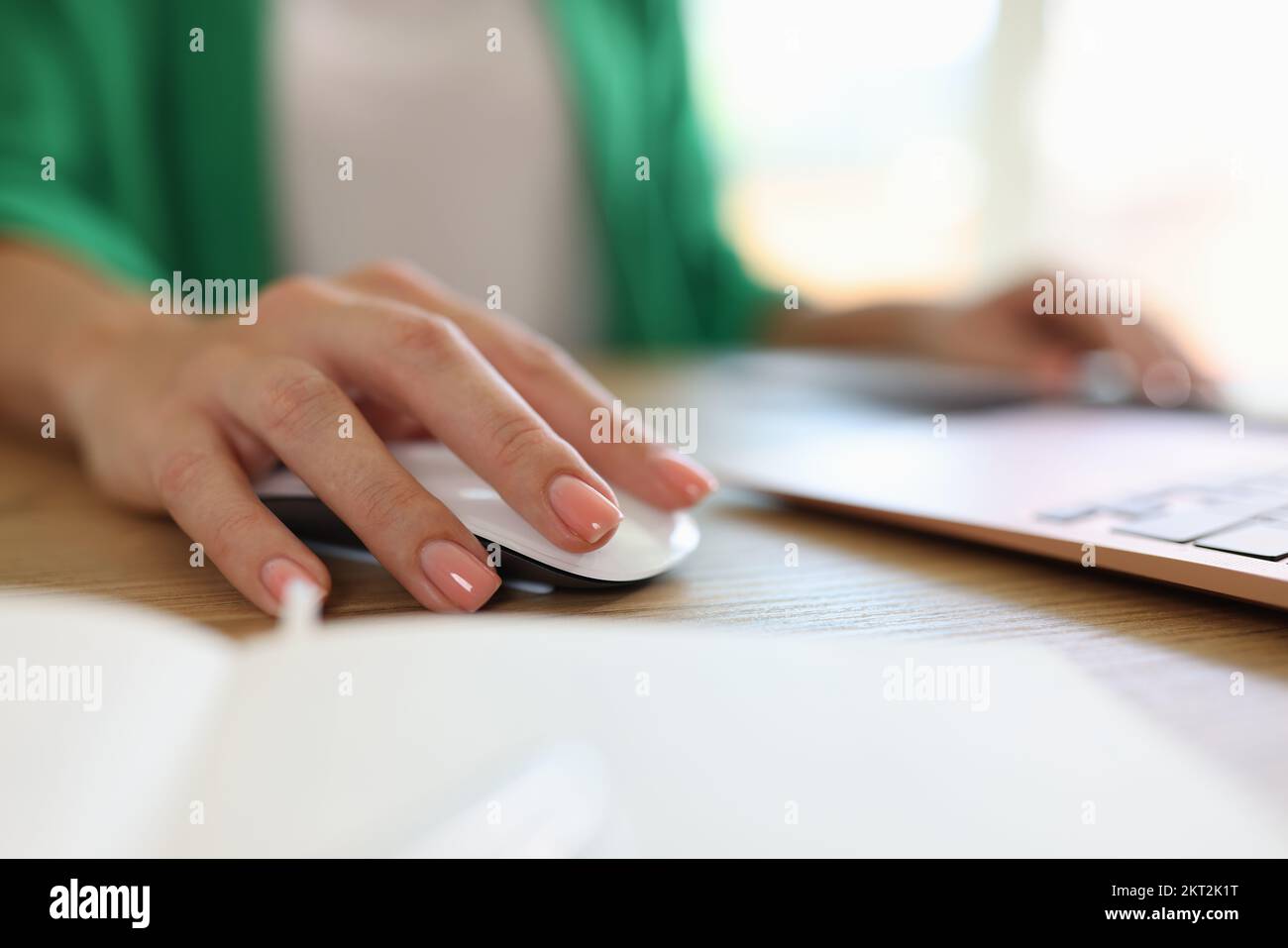 Employee holds computer mouse in her hand while working at office desk ...