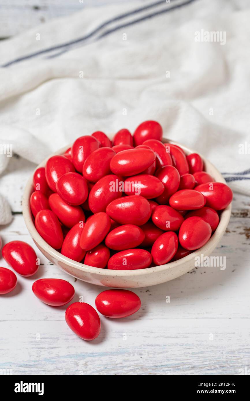 Red chocolate dragee. Chocolate dragee on a white wood background ...