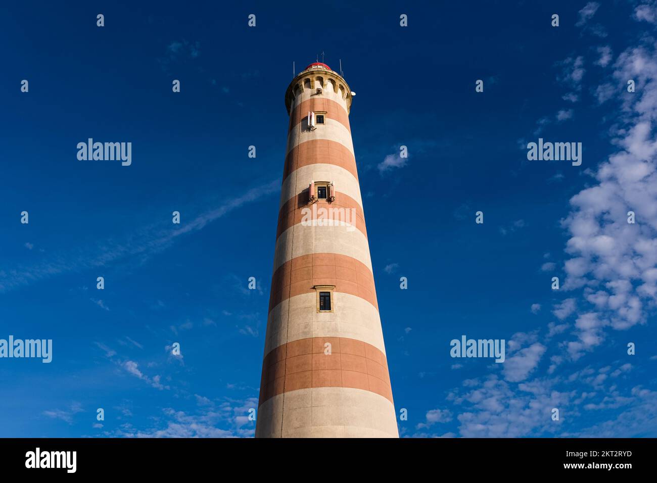 View of the old striped lighthouse and the blue sky. The main purpose ...