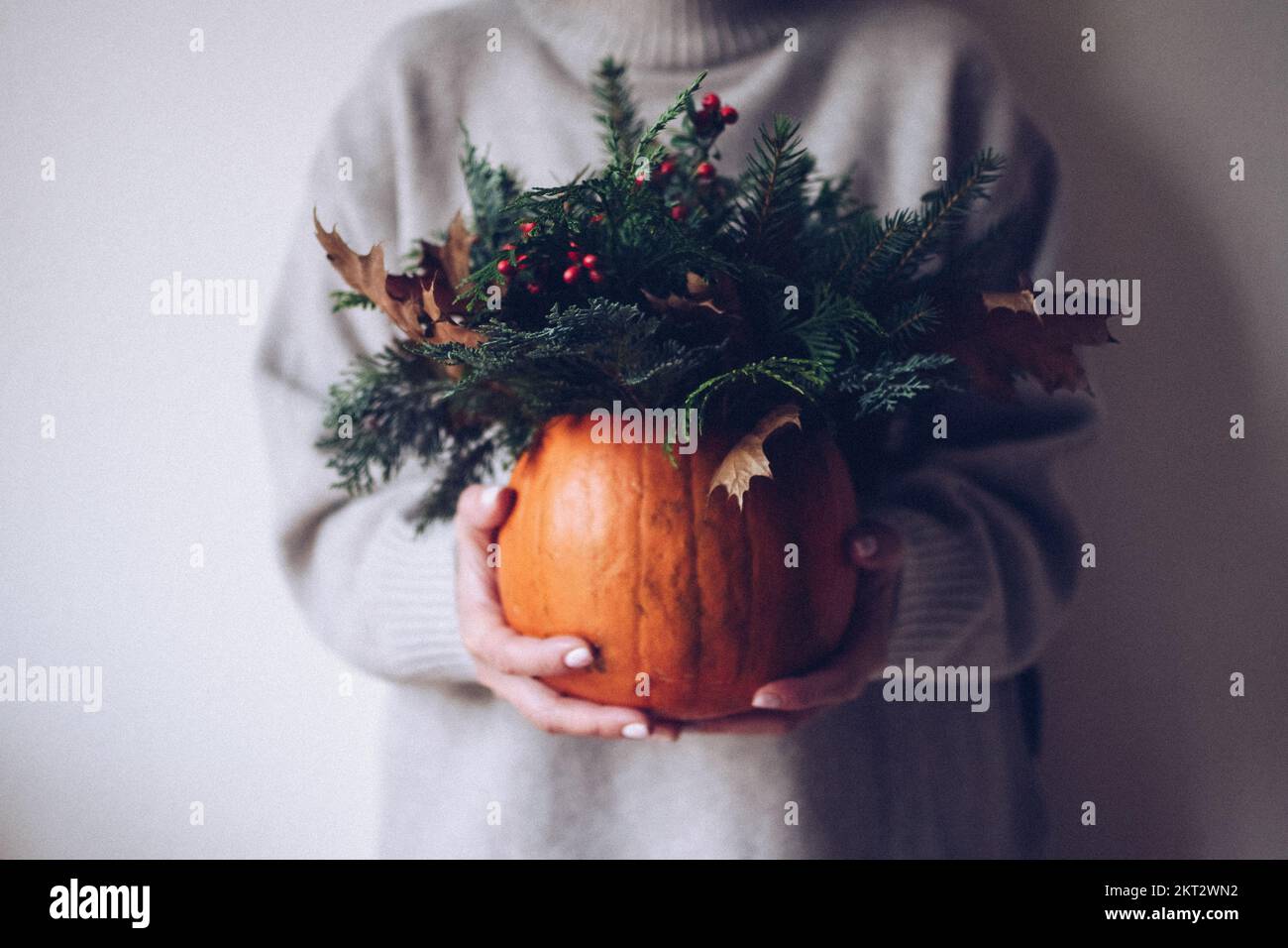 Rich autumn bouquet with a pumpkin in the hands of a girl on a light ...