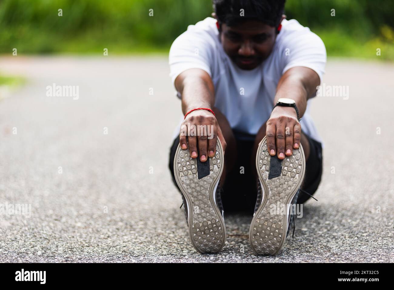 sport runner black man wear watch he sitting pull toe feet stretching ...
