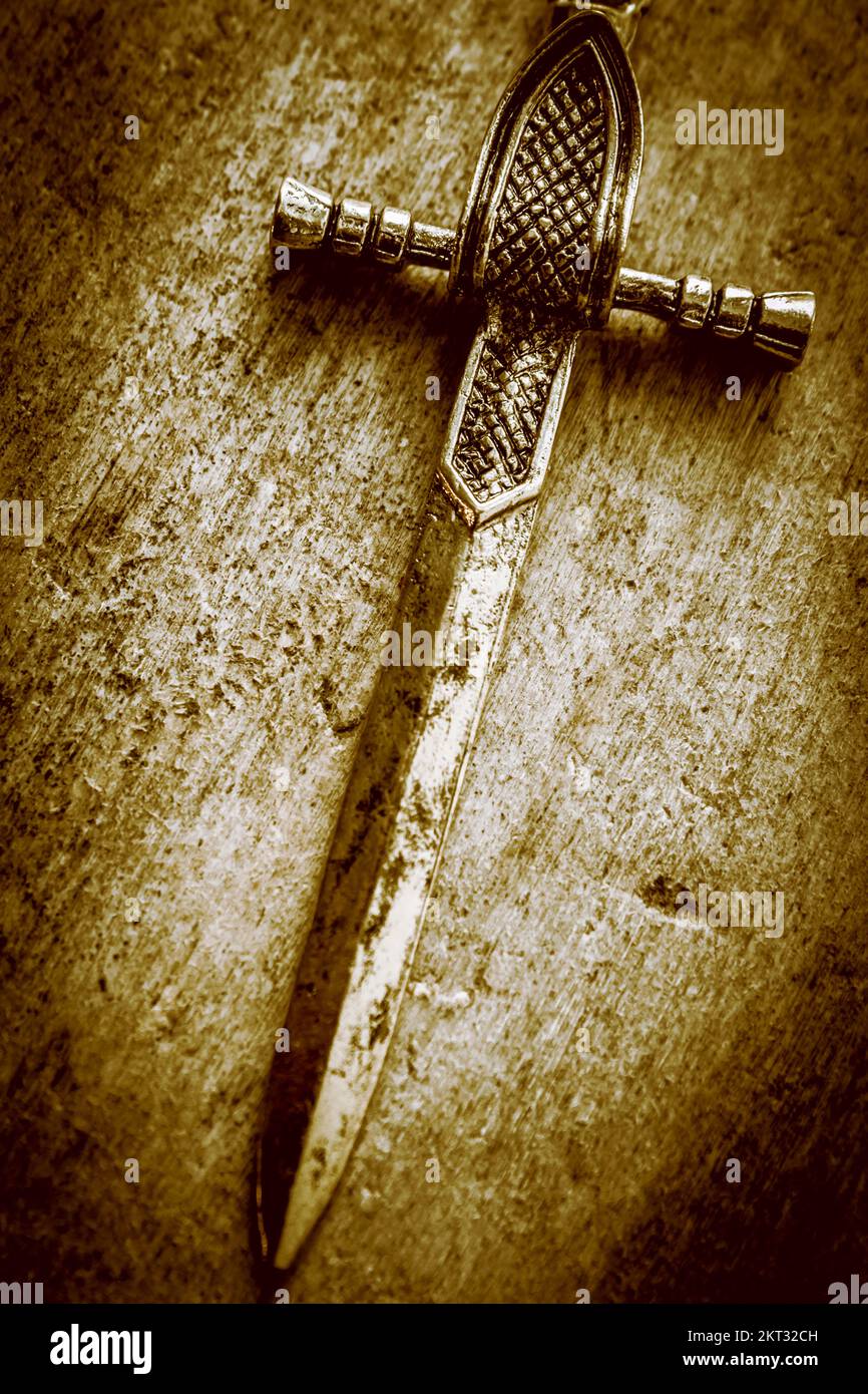 Rustic object art on a antique sword on grunge wood surface. Battle ...