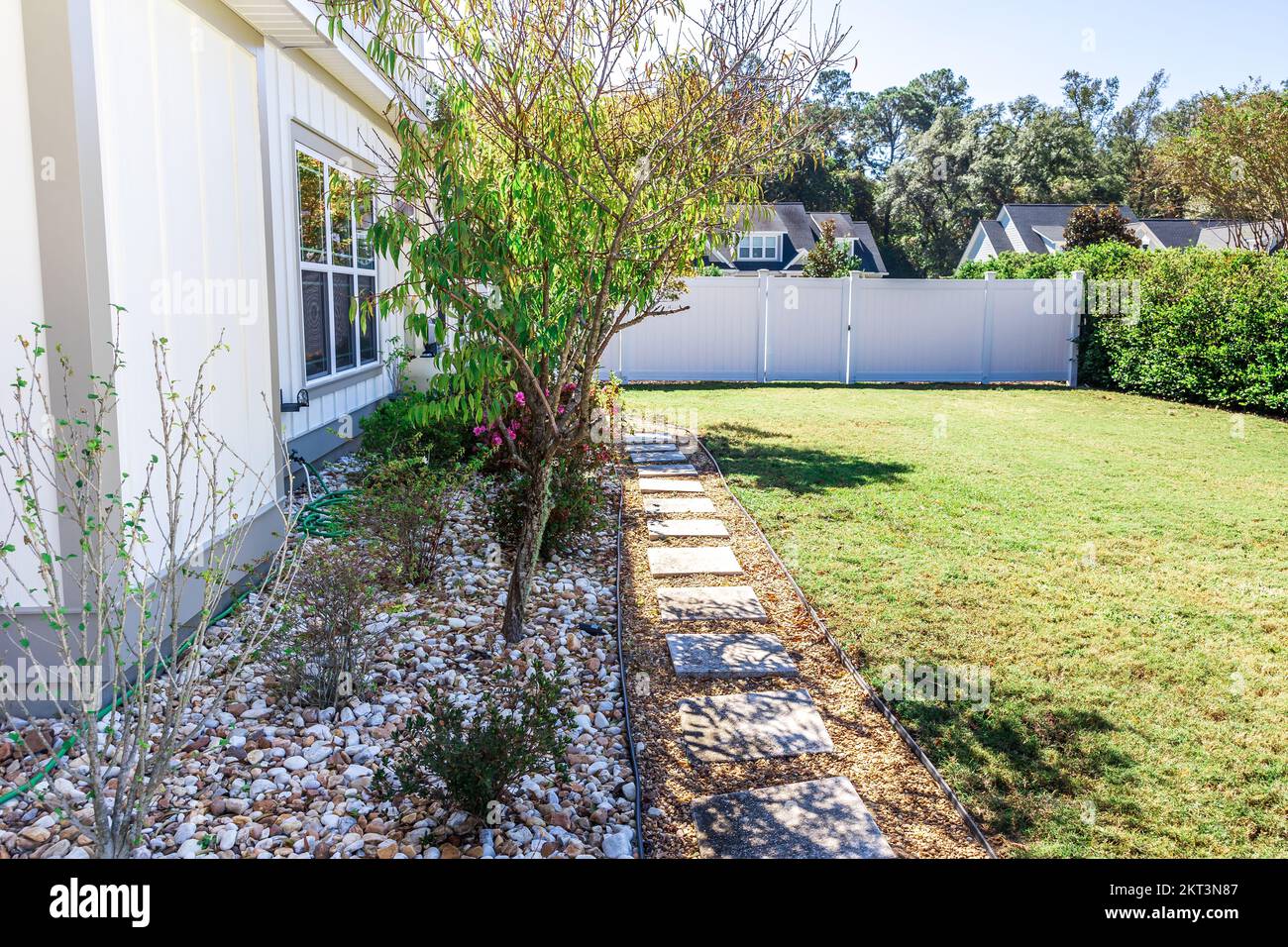 A landscaped small side yard of a new construction house with a young ...