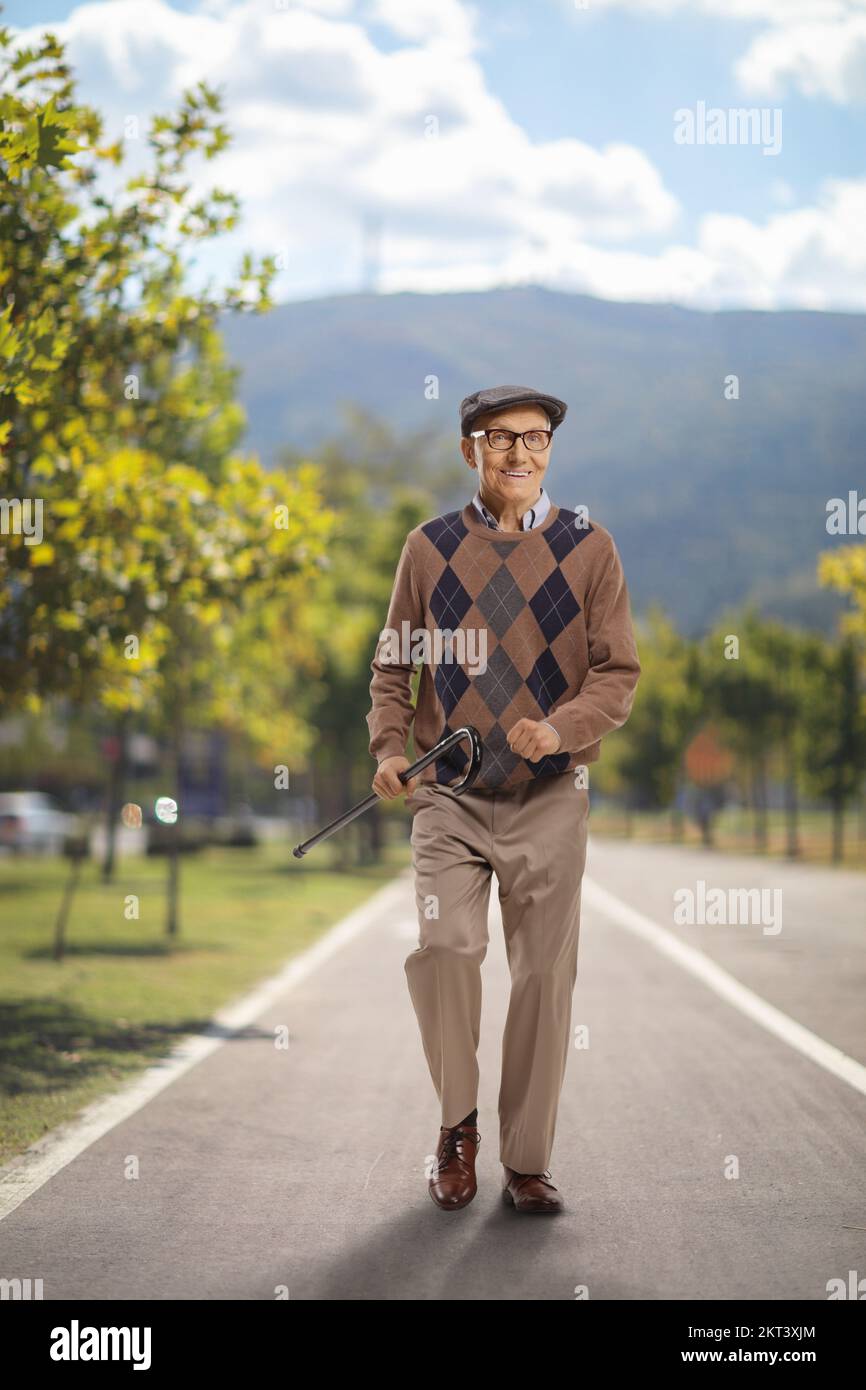 Happy elderly man walking on a pedestrian track Stock Photo - Alamy